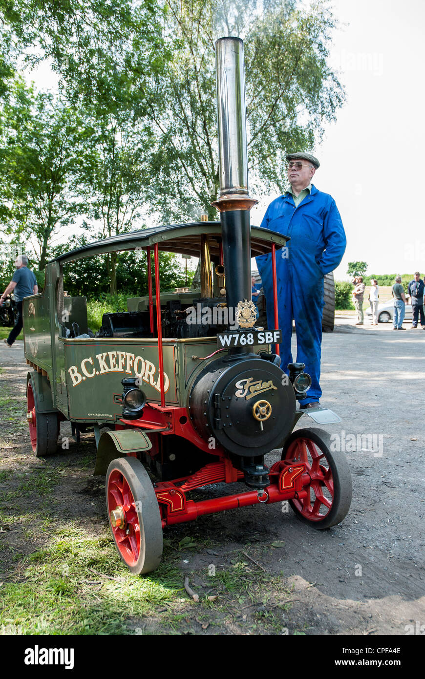 Small steam engine with driver in blue overalls Stock Photo - Alamy