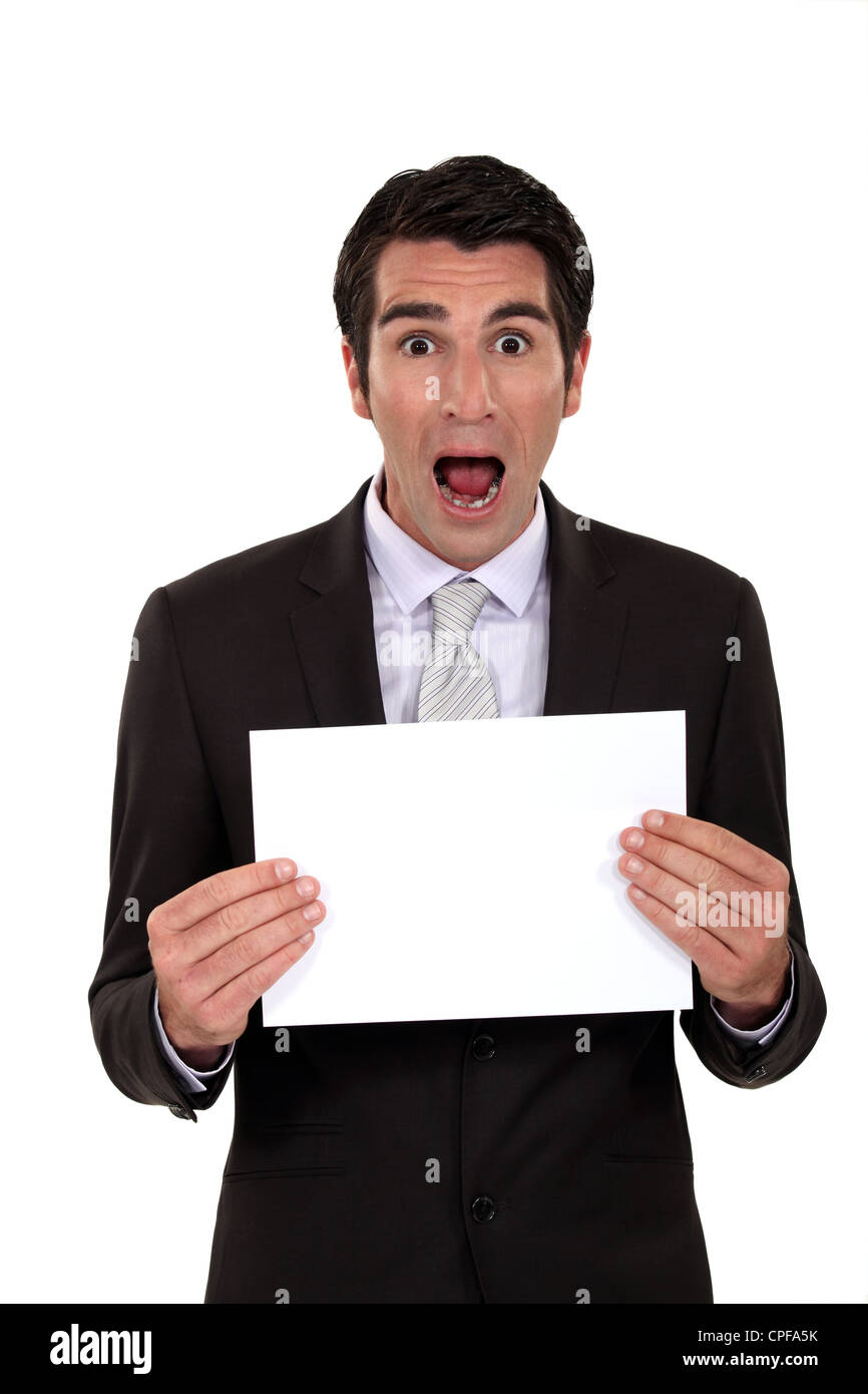 Shocked businessman holding poster Stock Photo - Alamy