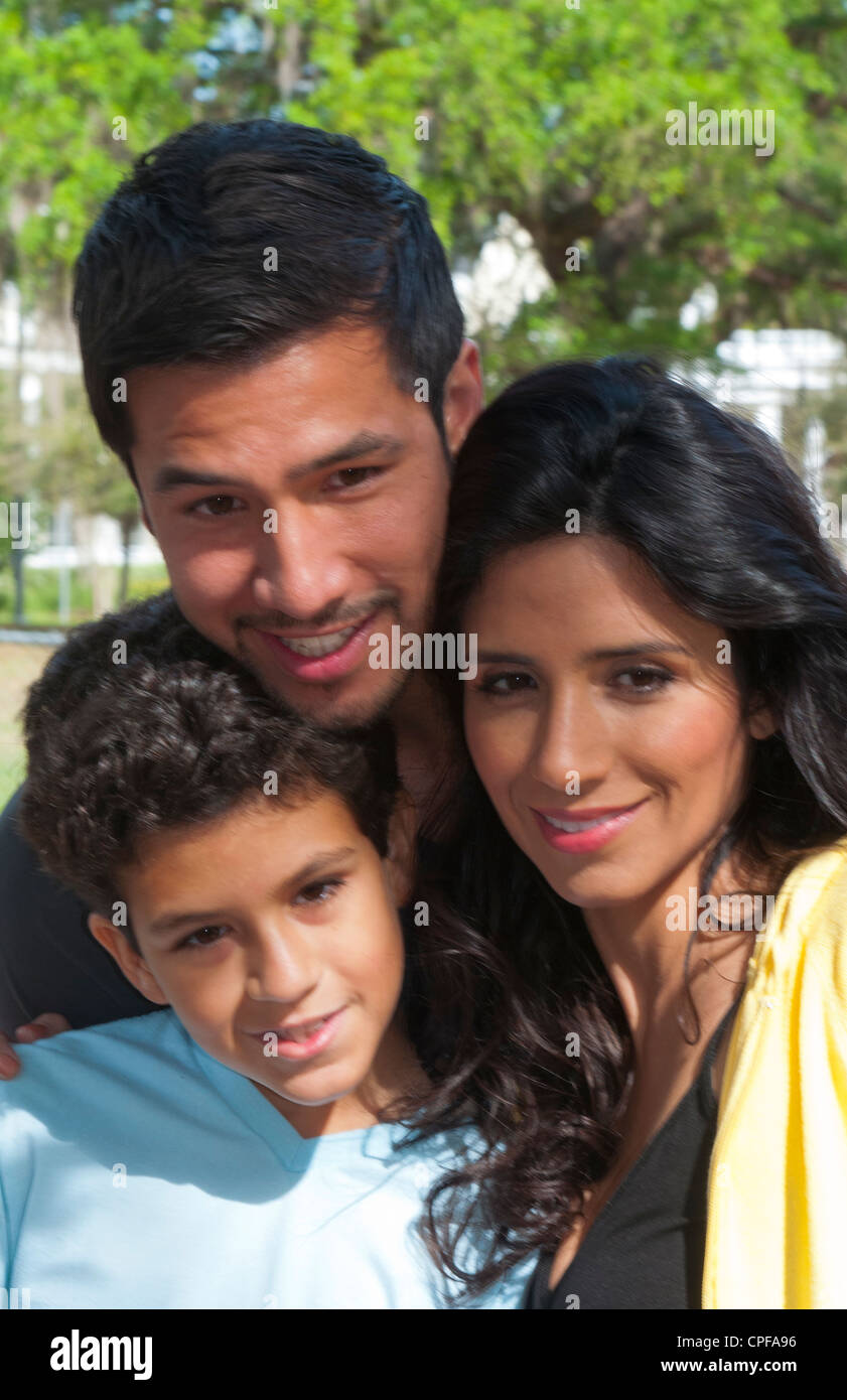Hispanic Spanish family in park outdoors portrait with holding and love ...