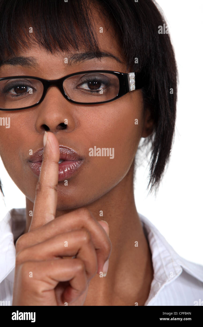 Businesswoman indicating quiet Stock Photo - Alamy