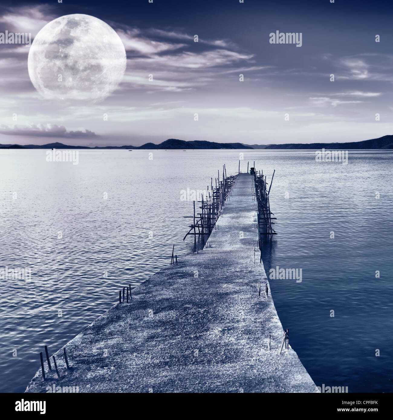 Pier on the sea at night time. Moon in the sky Stock Photo - Alamy