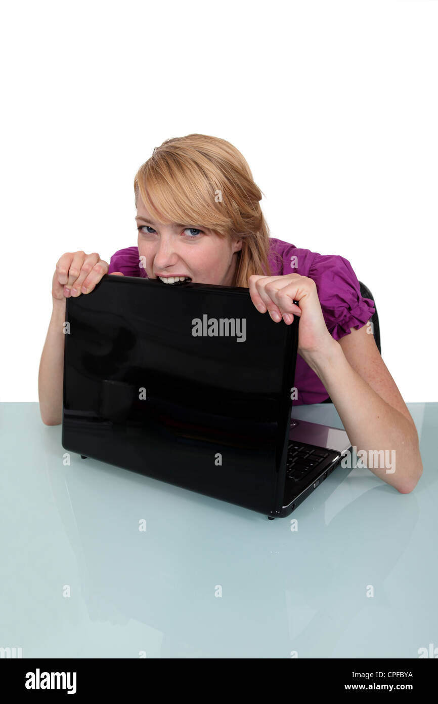 Young woman biting her laptop Stock Photo - Alamy