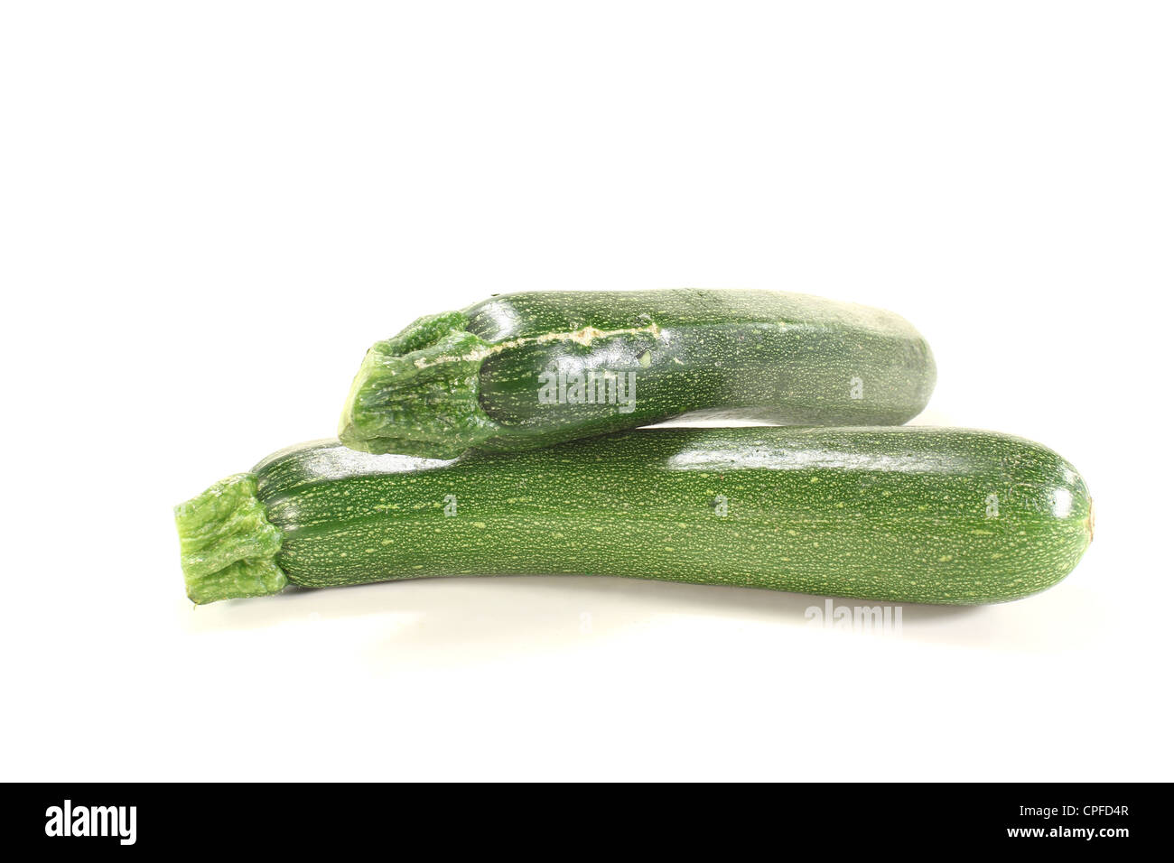 green whole Courgette on a light background Stock Photo - Alamy