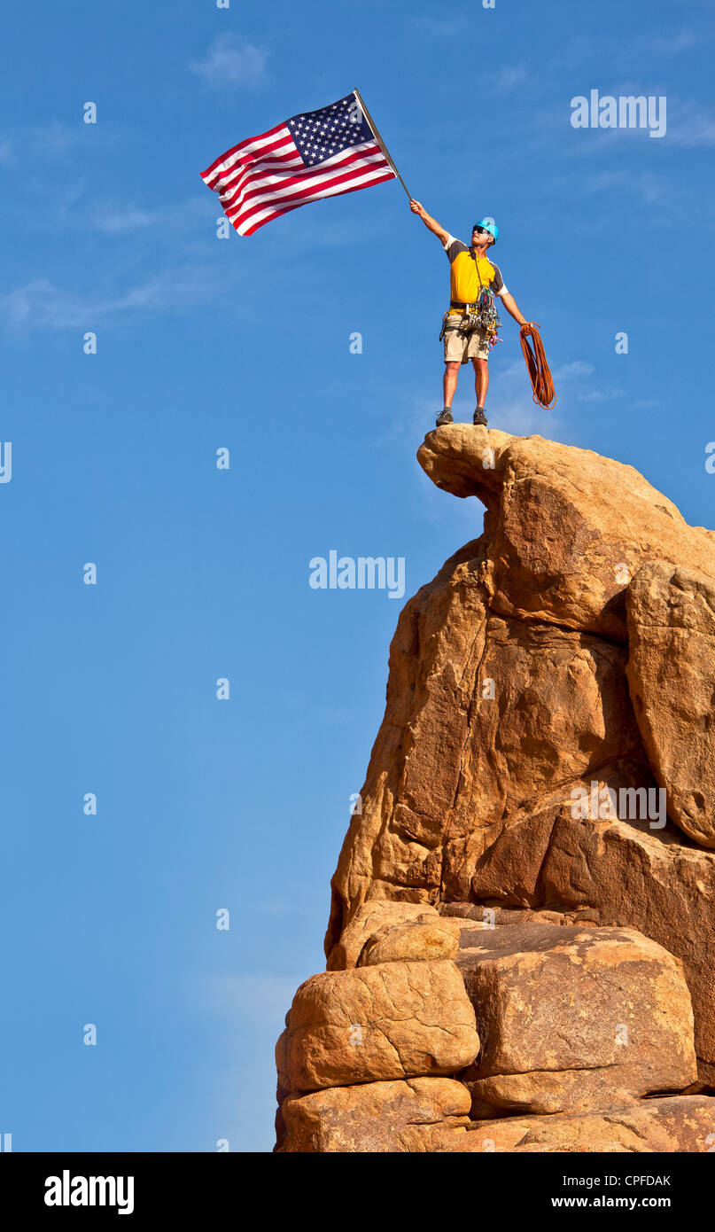 Climber waves an American flag on the summit after a challenging ascent ...