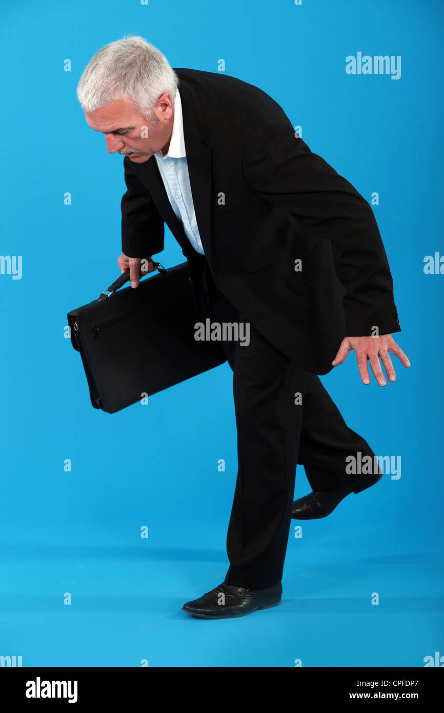 A mature businessman off balance Stock Photo - Alamy