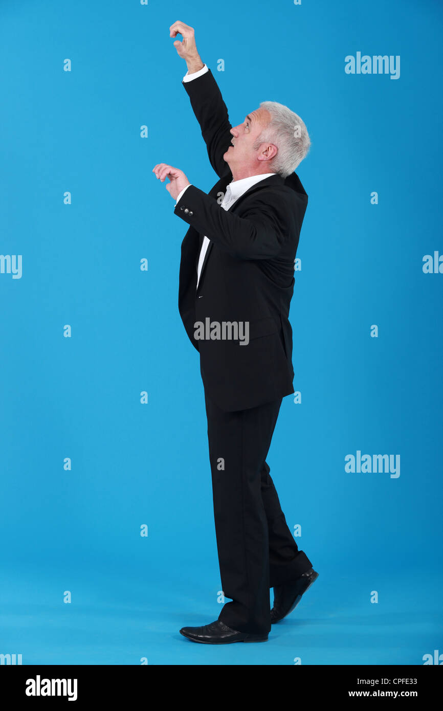 Senior businessman reaching upwards Stock Photo - Alamy