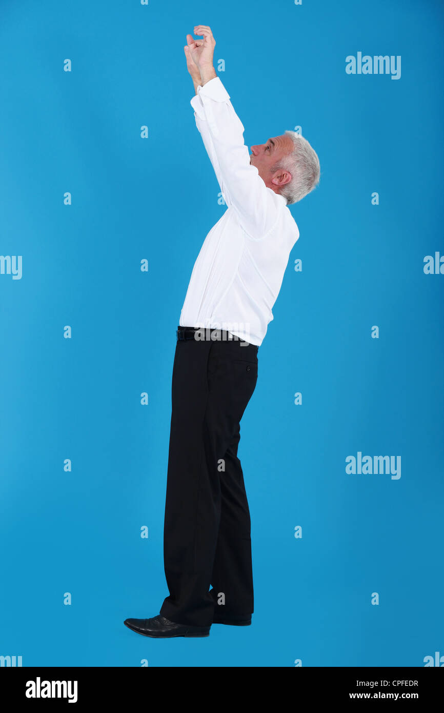 Businessman reaching up Stock Photo - Alamy