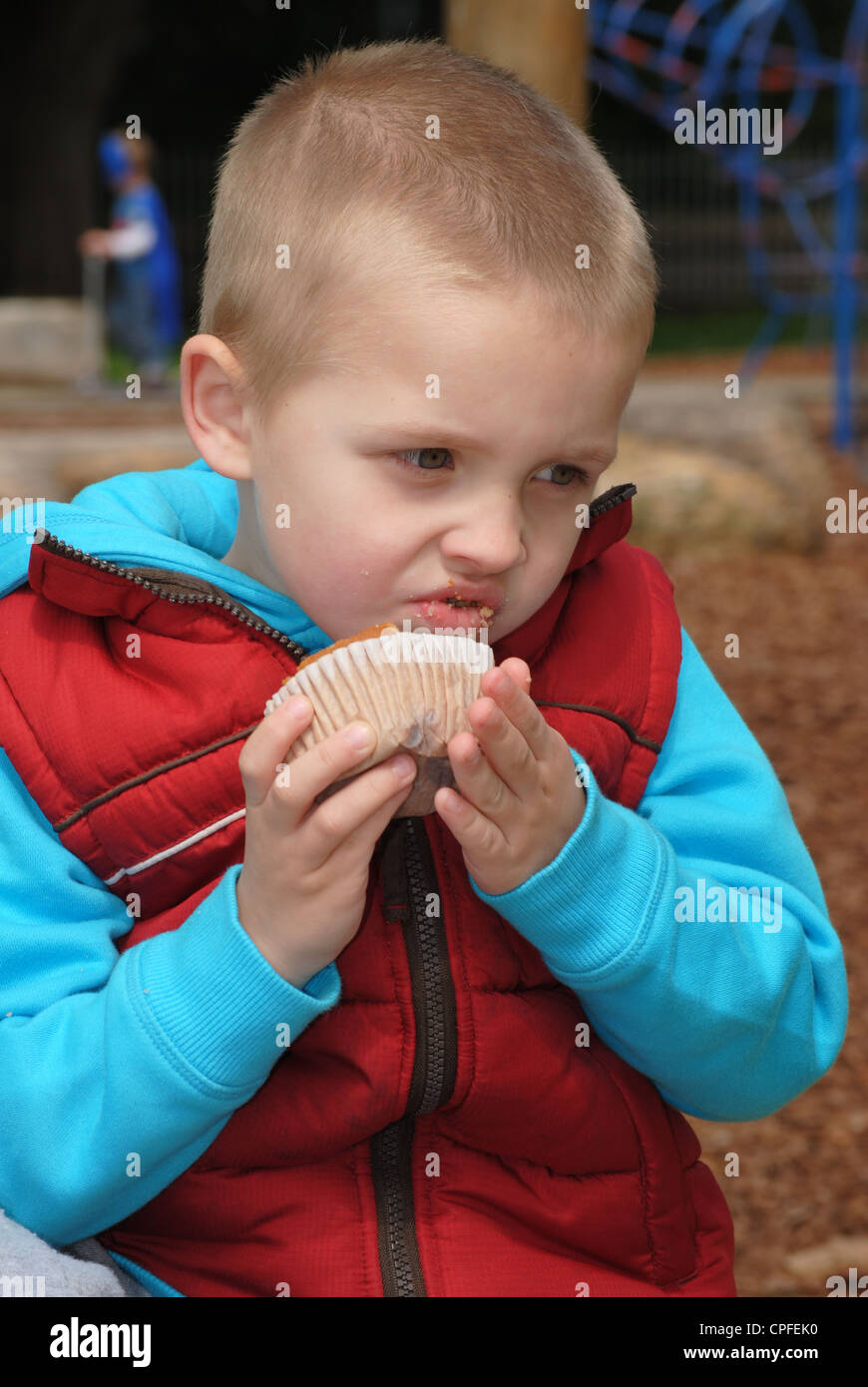 little blonde boy eating muffin in the park Stock Photo - Alamy