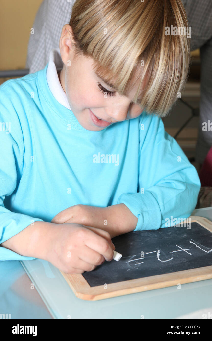 Little boy writing on a slate Stock Photo - Alamy