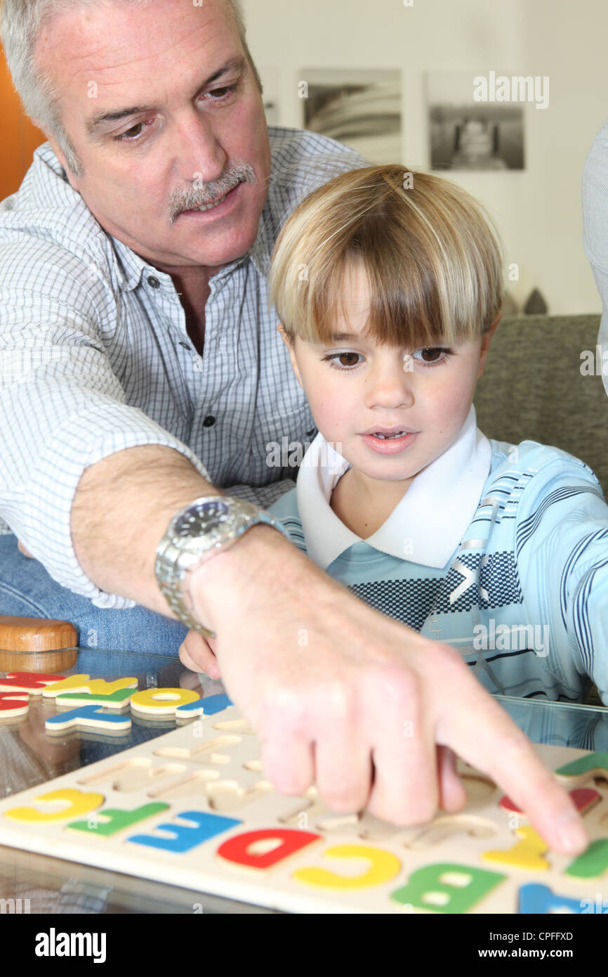 grandfather learning his grandson to read Stock Photo - Alamy