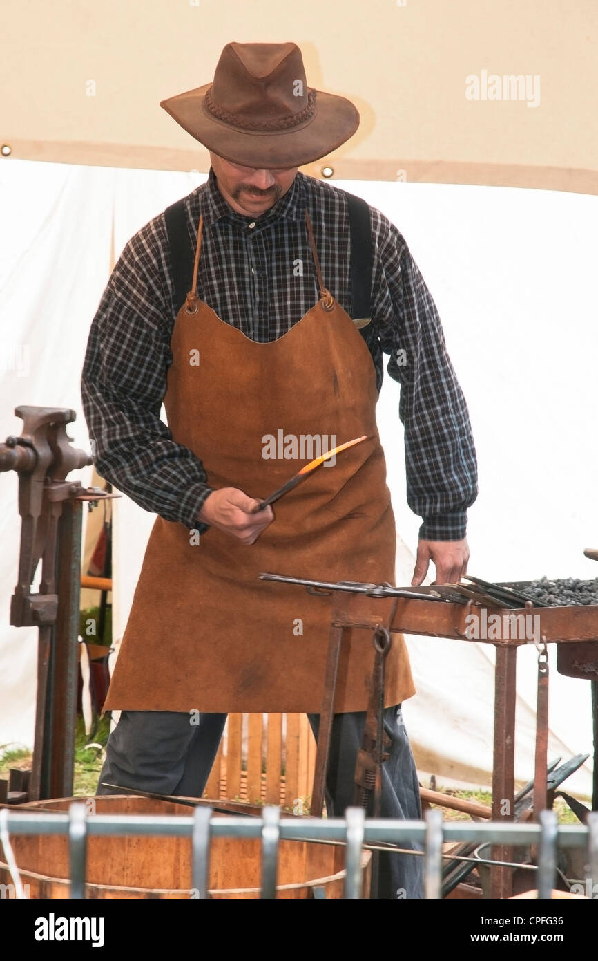 The blacksmith is working in forge shop of military camp, Civil War ...