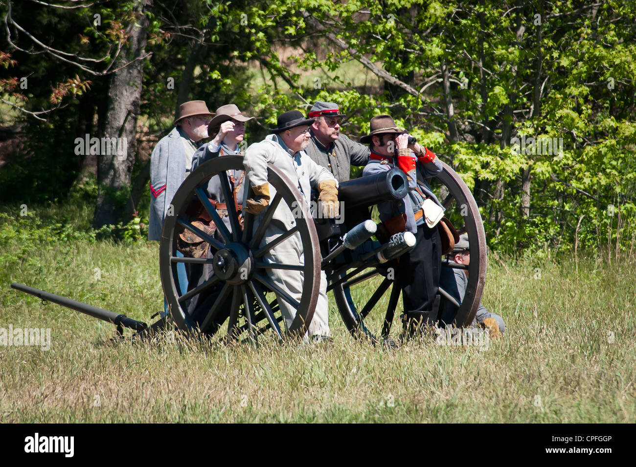 Group of Confederate military stand near cannon and watch course battle ...