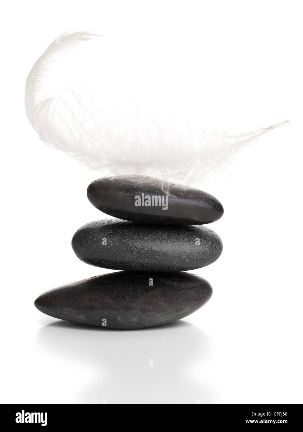 White feather on stack of black pebbles over white background - balance ...