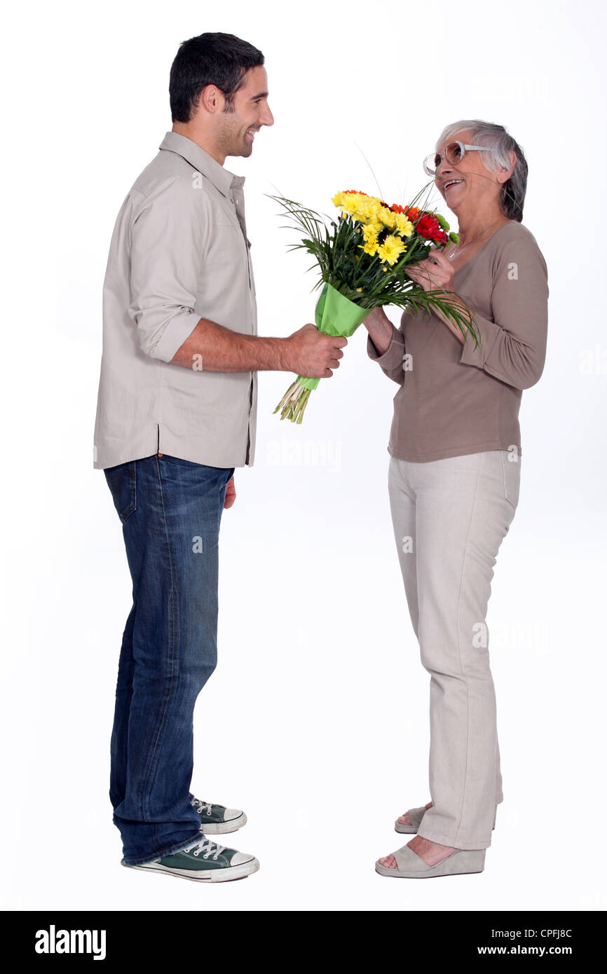 Son giving mother flowers Stock Photo - Alamy