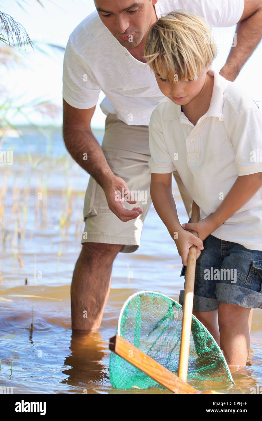 Father teaching son to fish with net Stock Photo - Alamy