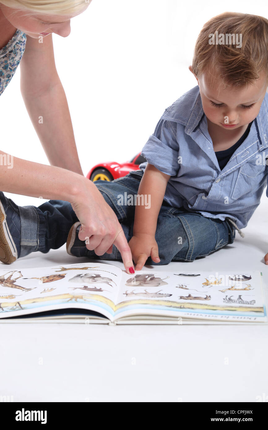 Mother and child looking at a book Stock Photo - Alamy