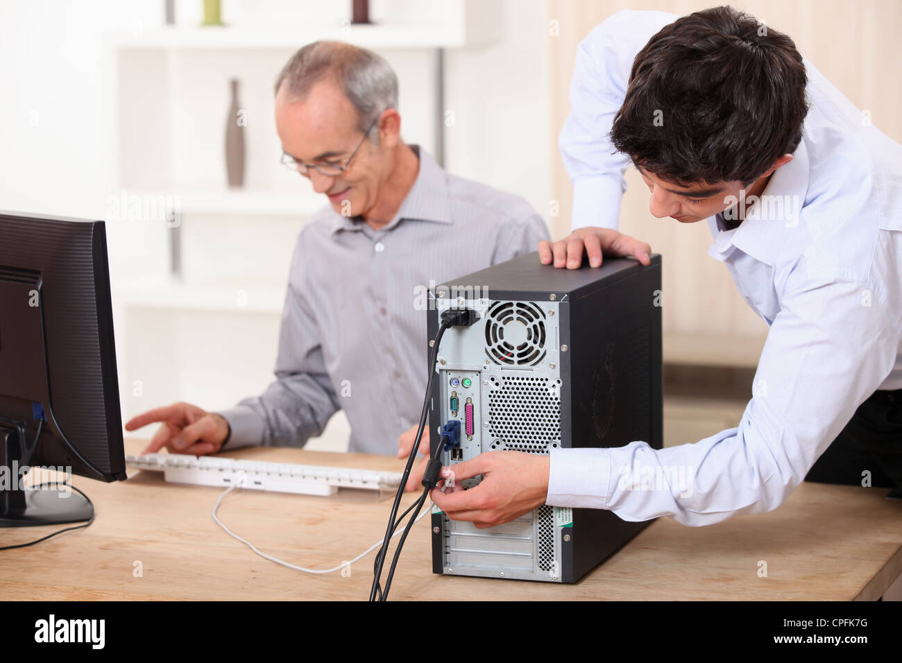 Young plugging computer Stock Photo - Alamy