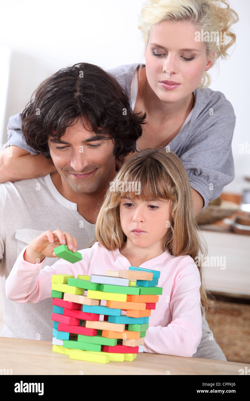Parents building blocks with their daughter Stock Photo - Alamy