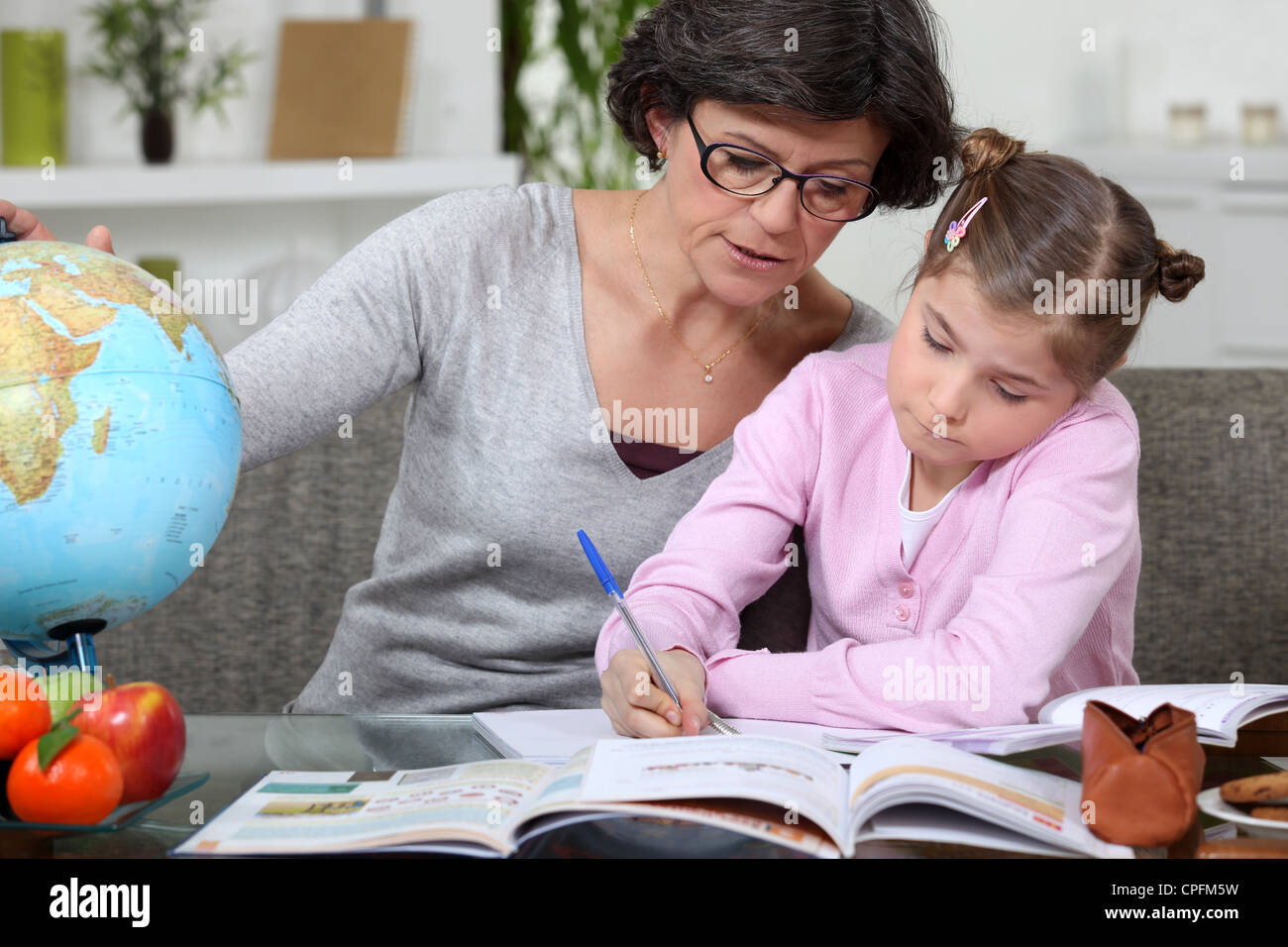 Mother teaching daughter from home Stock Photo - Alamy