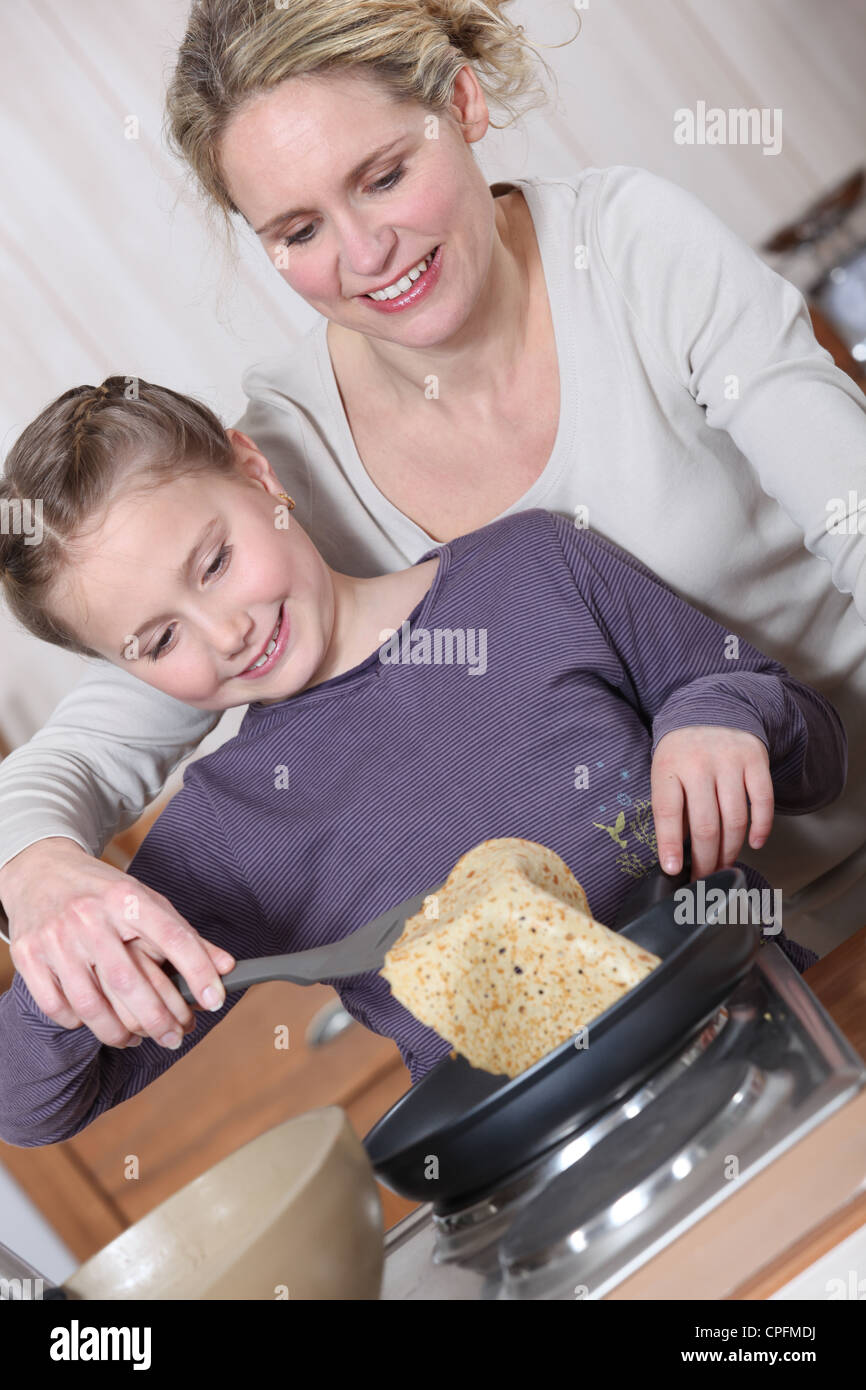 Mother and daughter cooking pancakes Stock Photo - Alamy