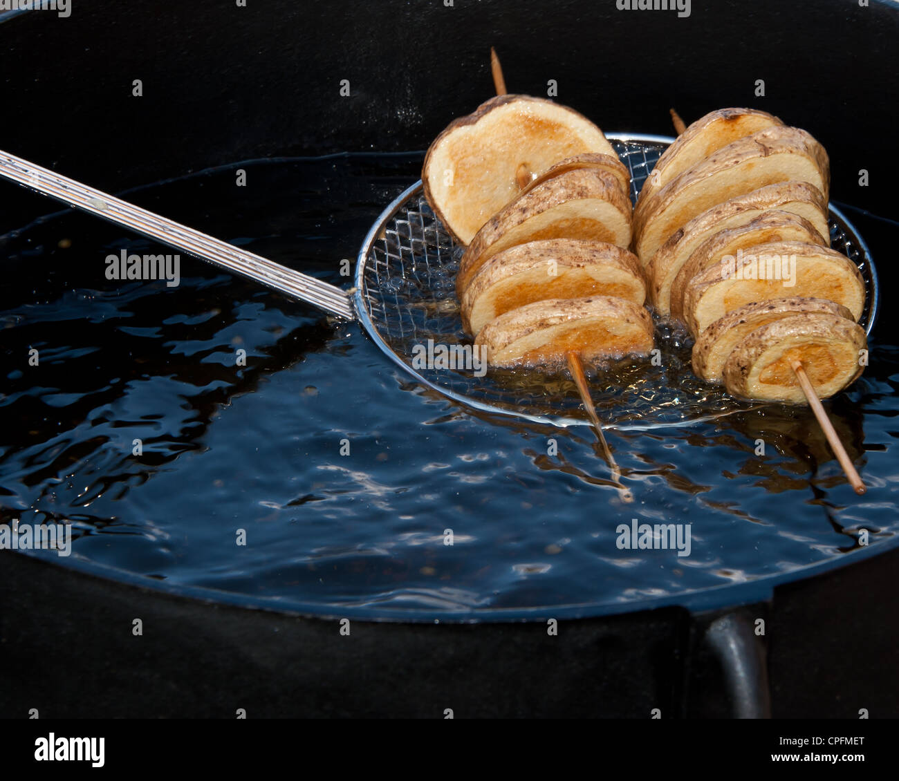Potato slices cooked in the pitchfork fondue Stock Photo - Alamy