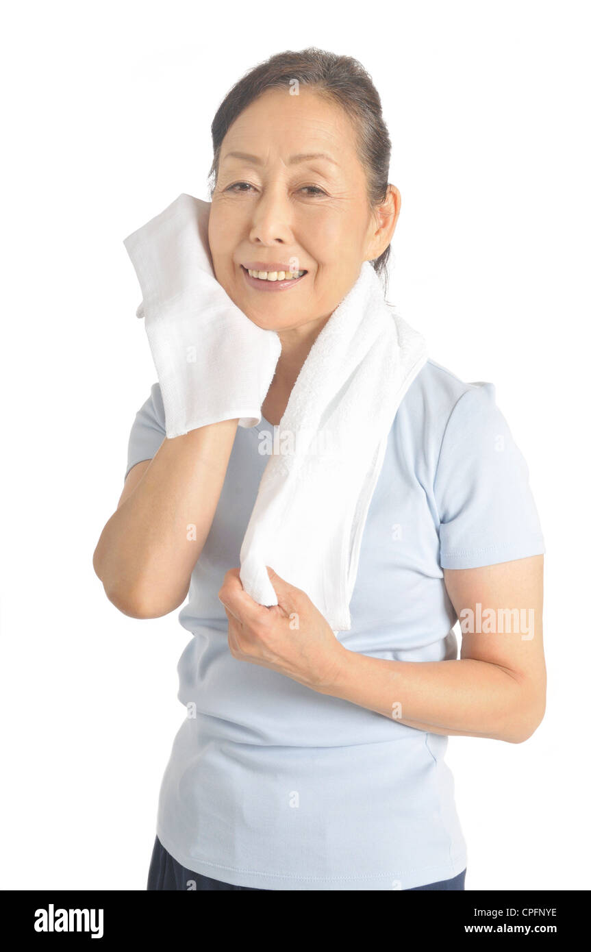 Senior woman wiping off sweat by towel Stock Photo - Alamy