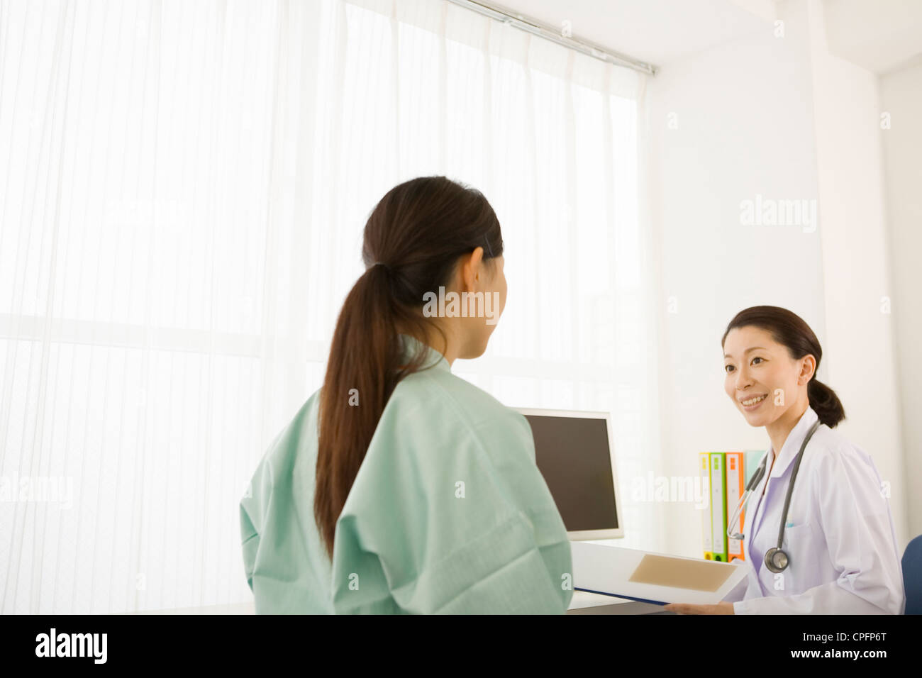 Female doctor talking to patient Stock Photo - Alamy