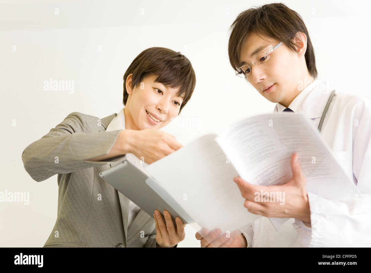 Pharmaceutical sales representative showing file to doctor Stock Photo ...
