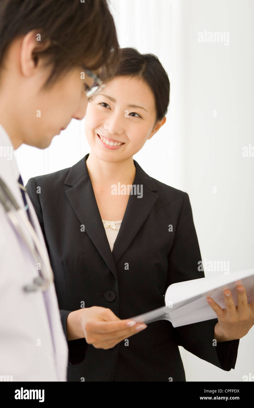 Pharmaceutical sales representative showing file to doctor Stock Photo ...