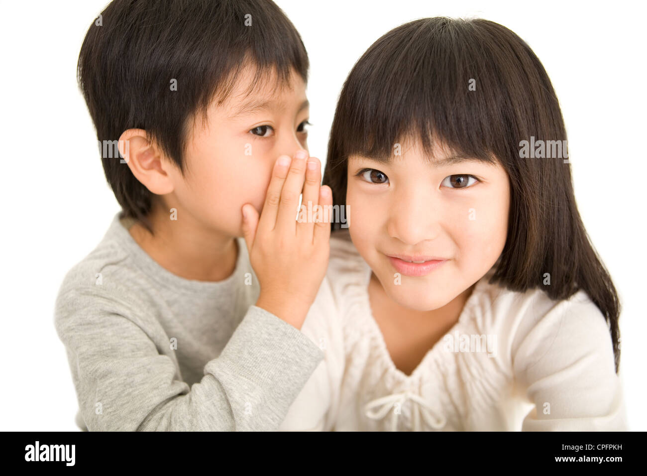 Boy whispering to girl Stock Photo - Alamy