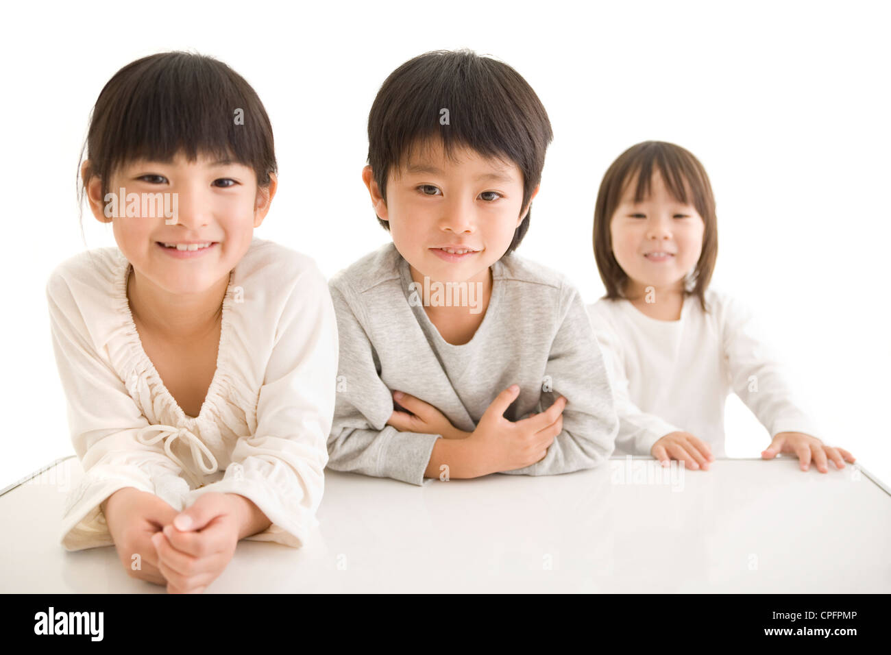 Three kids smiling Stock Photo - Alamy