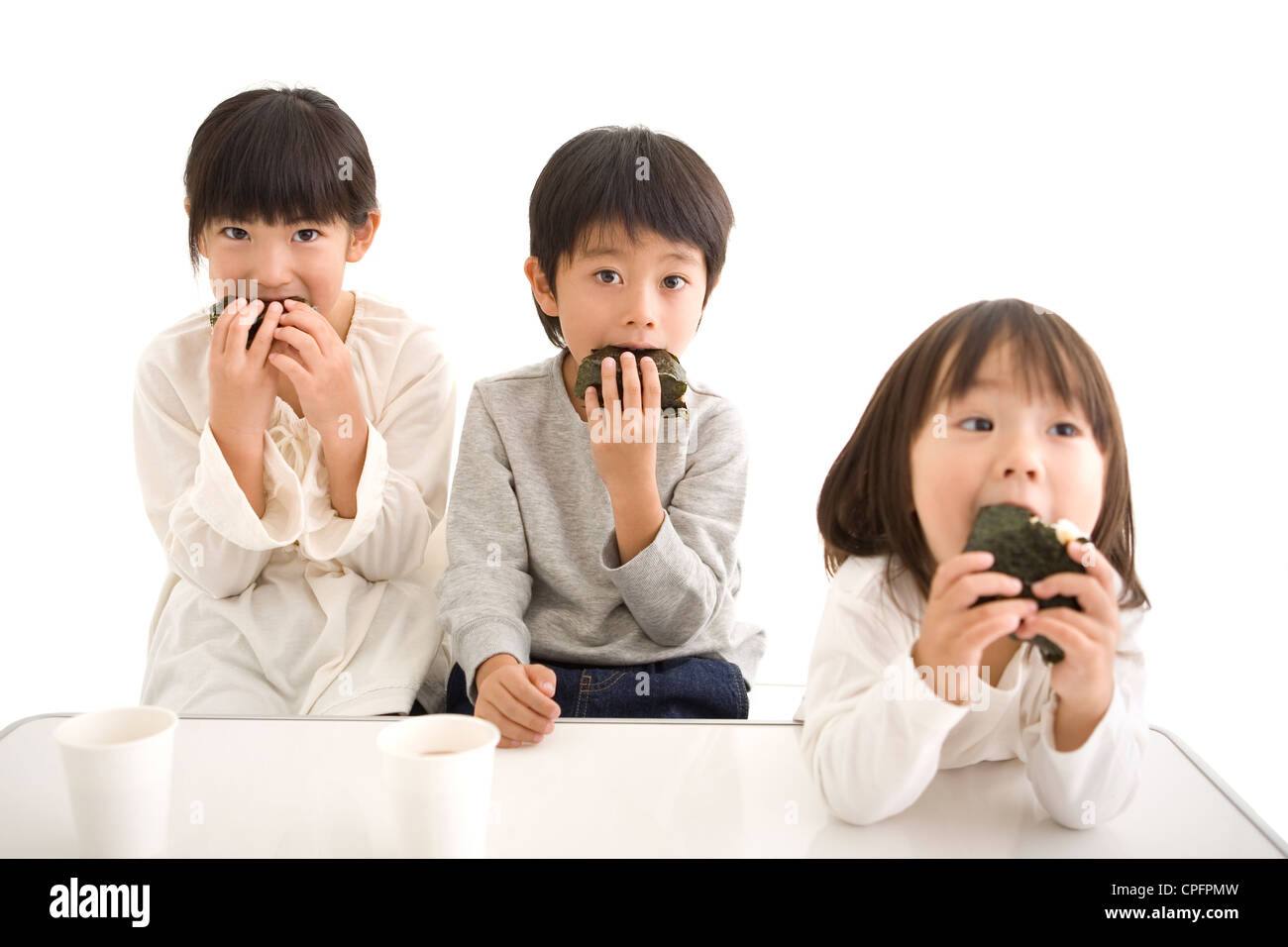 Three kids eating rice ball Stock Photo - Alamy