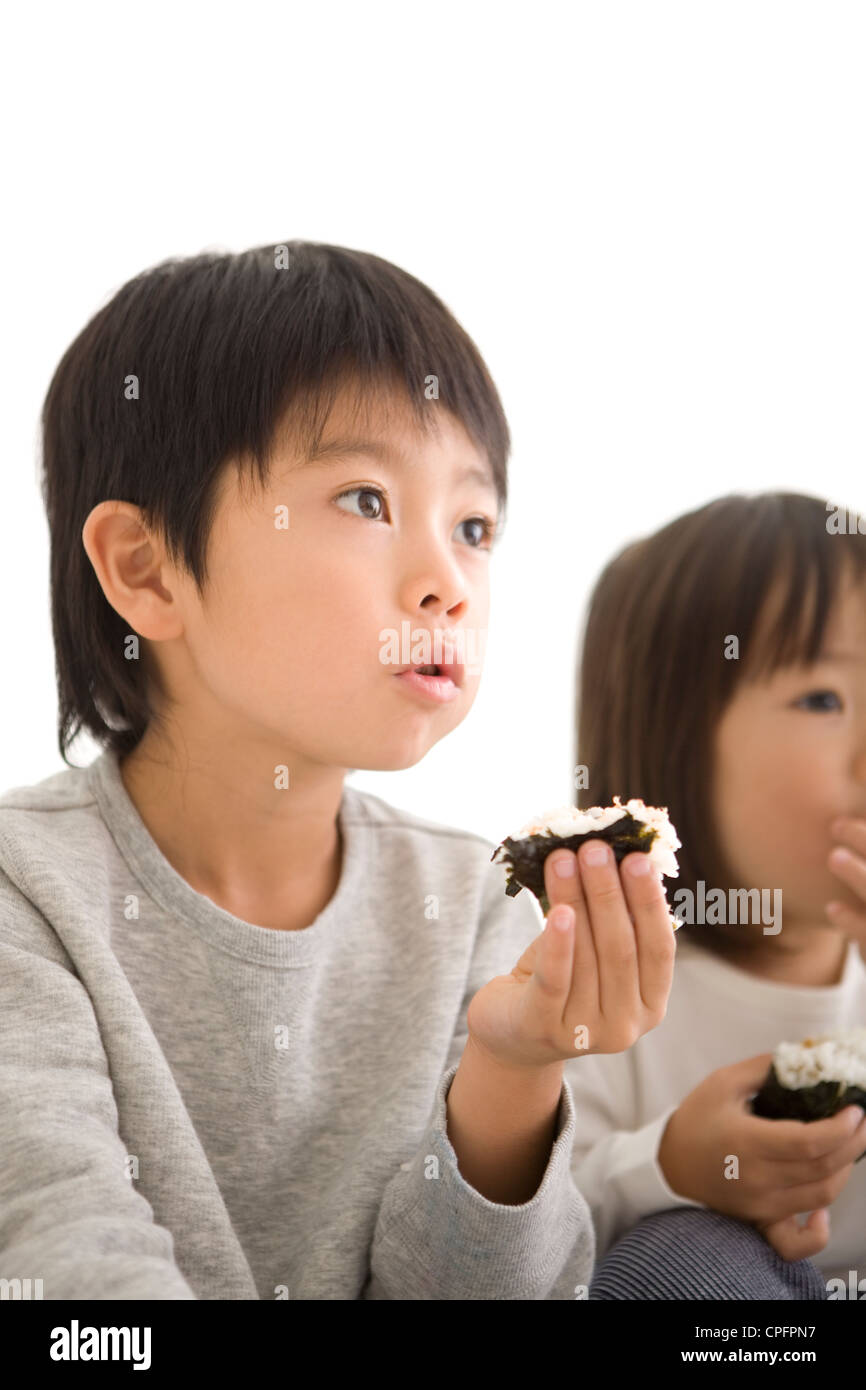 Two boys eating rice ball Stock Photo - Alamy