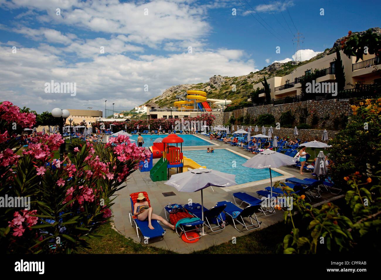 Holidaymakers relax in a swimming pool of Mareblue Village hotel in a ...
