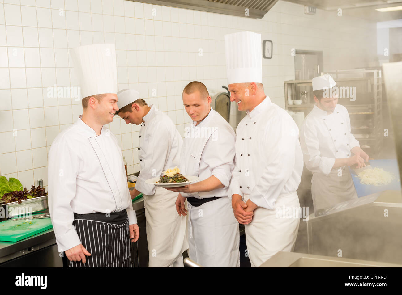 Professional kitchen busy team cooks and chef prepare meal Stock Photo ...