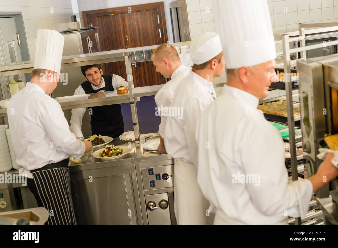 Group of cooks in professional kitchen prepare meals restaurant service ...