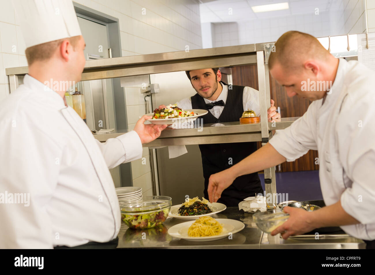 Professional kitchen cook prepare food service give meals to waiter ...