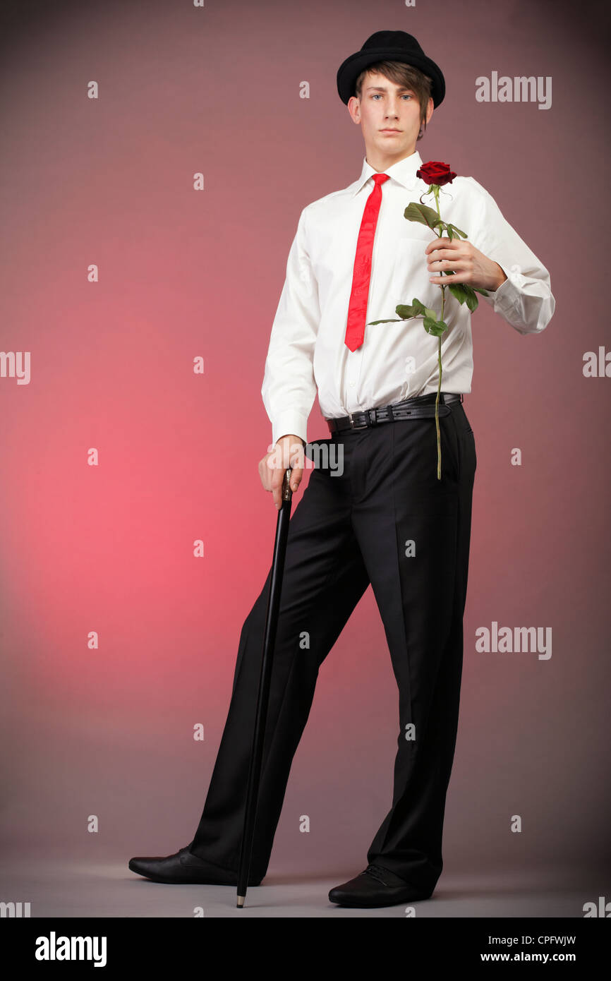 Young men with the red rose on colour background. Love and reflection ...
