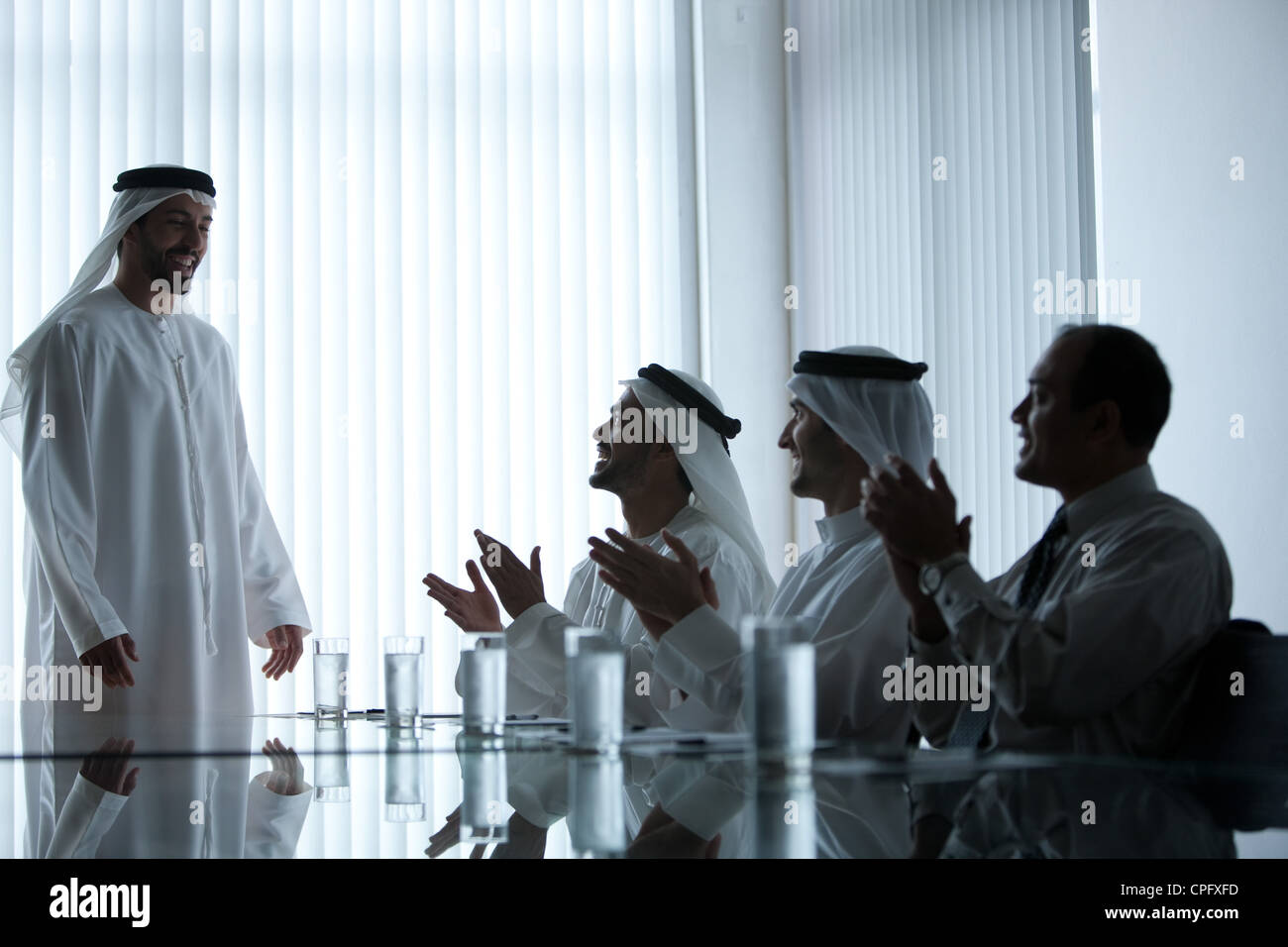 Four businessmen having a meeting in a conference room, clapping Stock ...