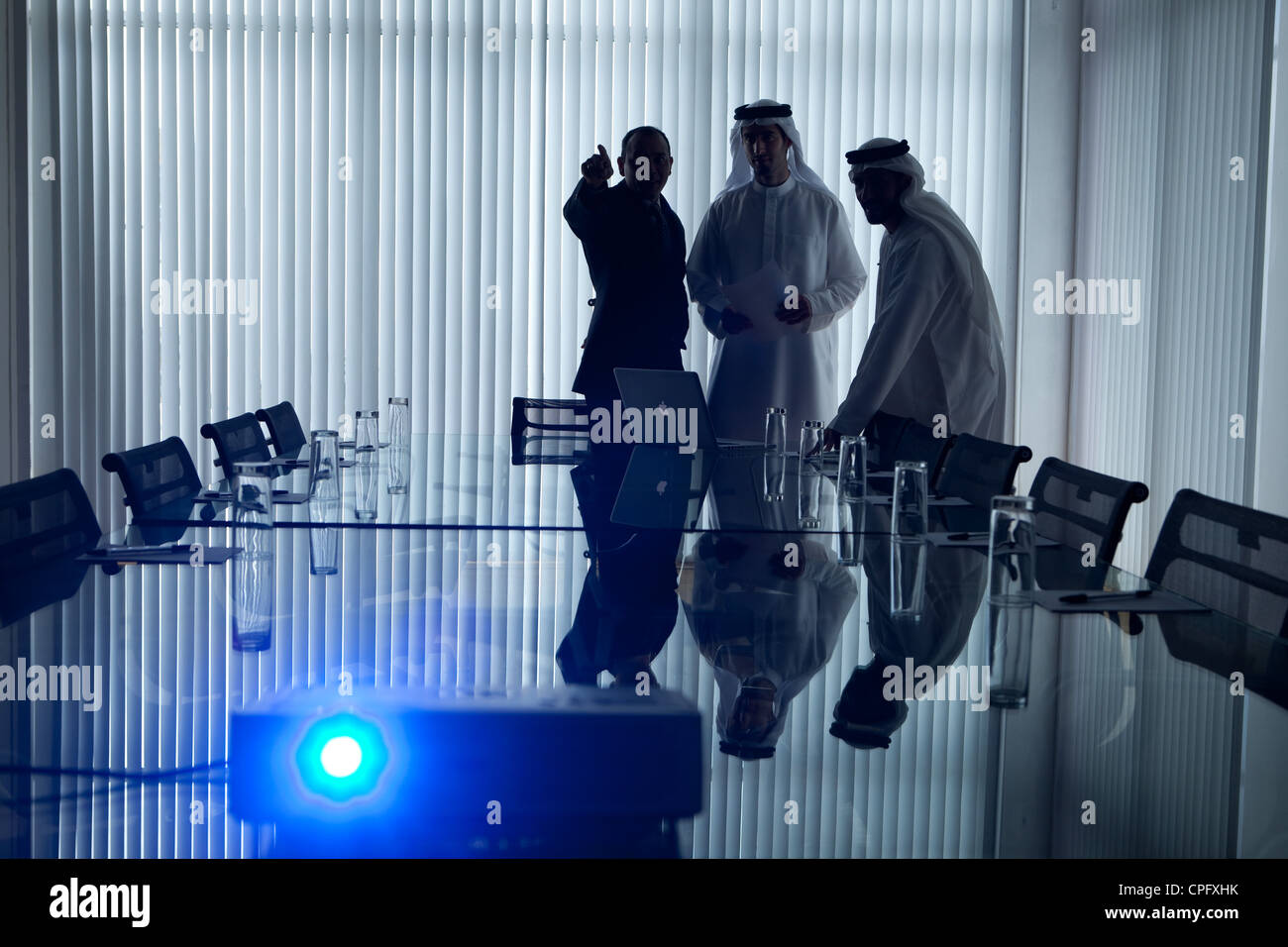 Three businessmen having a meeting in a conference room, man pointing ...