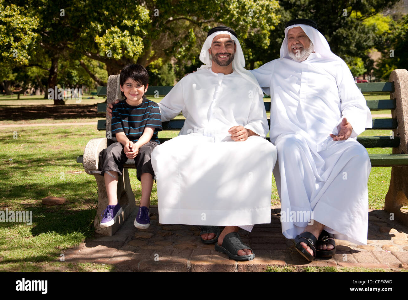 Portrait of male multi-generation arab family sitting on bench at the ...