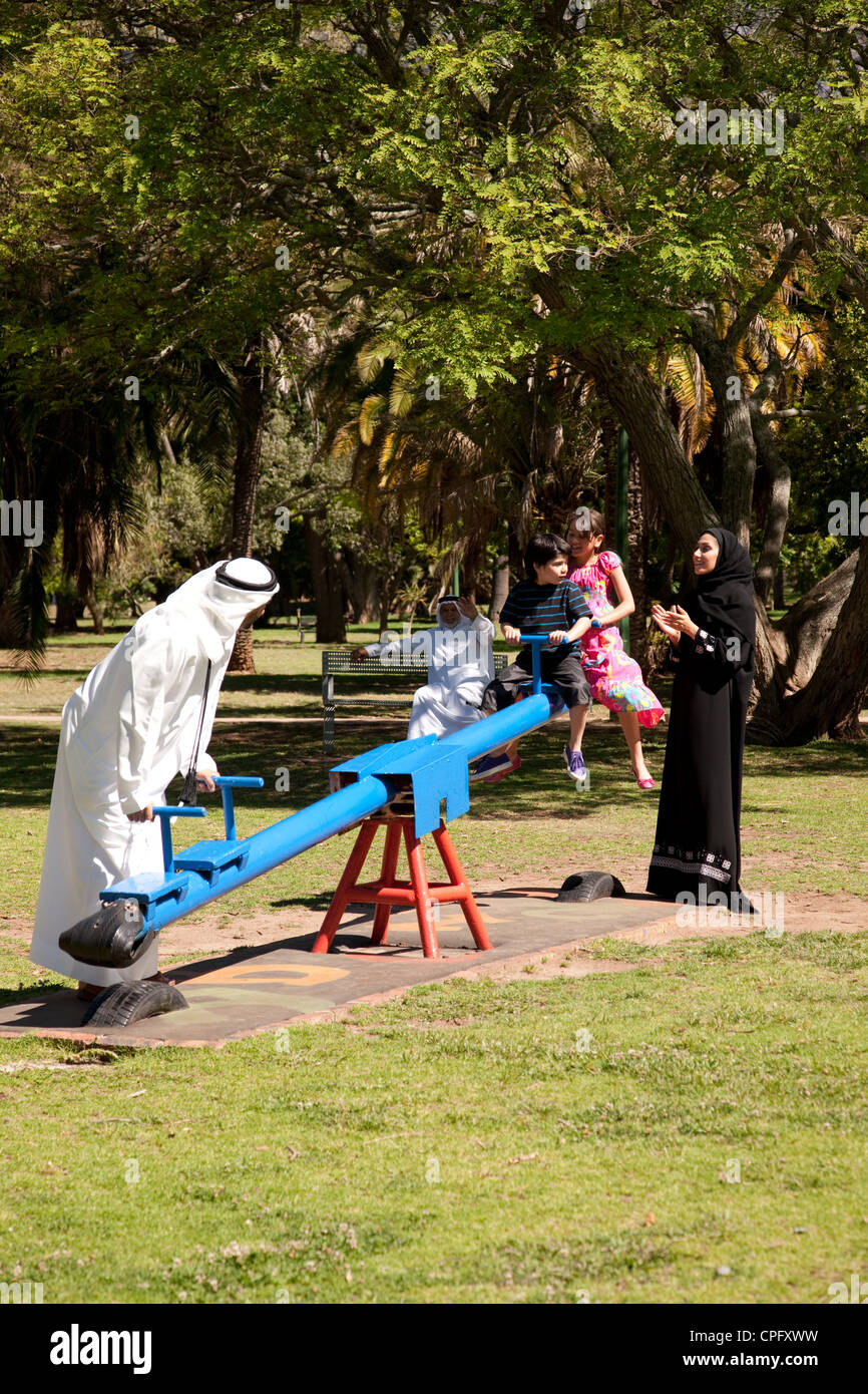 Multi-generation arab family at the park, children riding on the seesaw ...