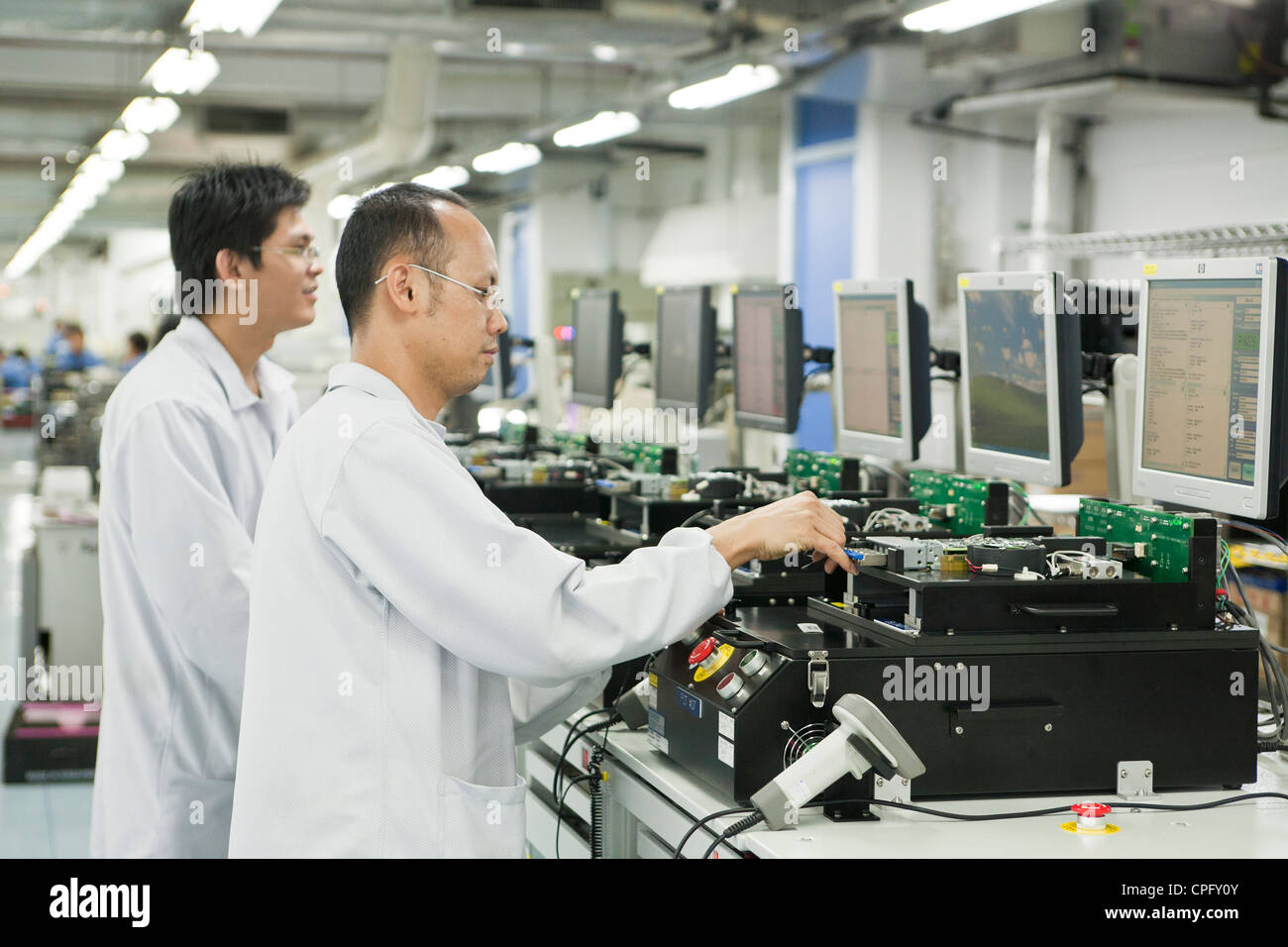 Workers assemble hand-held inventory computer devices on the assembly ...