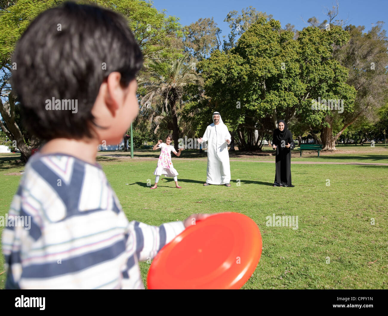 Arab family playing frisbee at the park, boy holding plastic disc Stock ...
