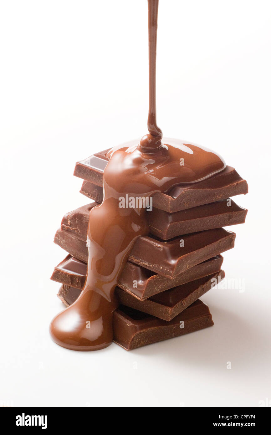 Melt Chocolate Dropping On Stack Of Chocolate Pieces Stock Photo - Alamy