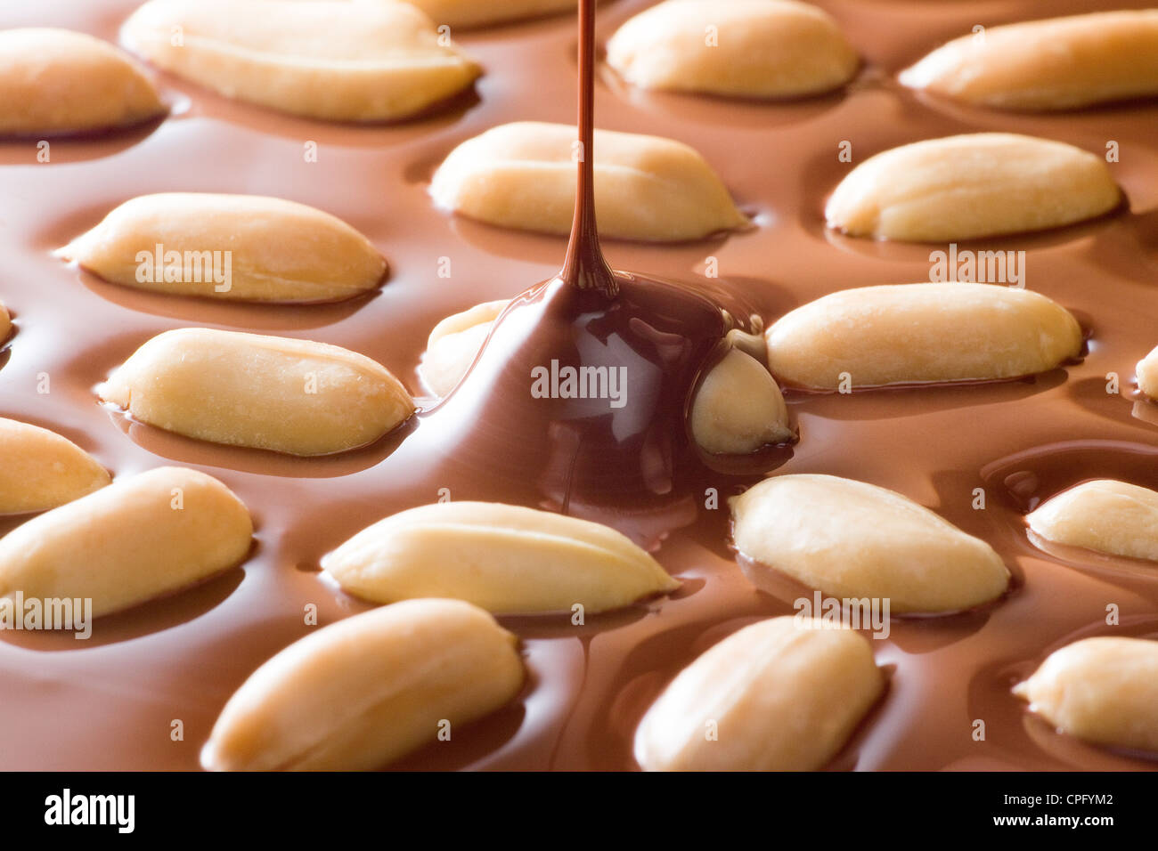 Chocolate Dropping On Peanuts Stock Photo - Alamy