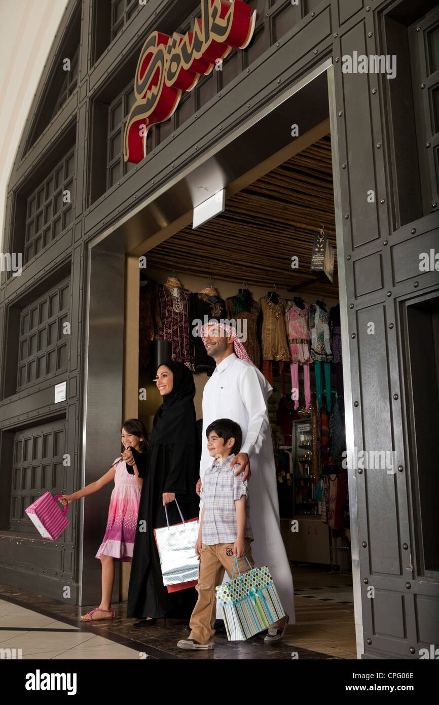 Arab family with shopping bag coming out of the middle eastern shop ...