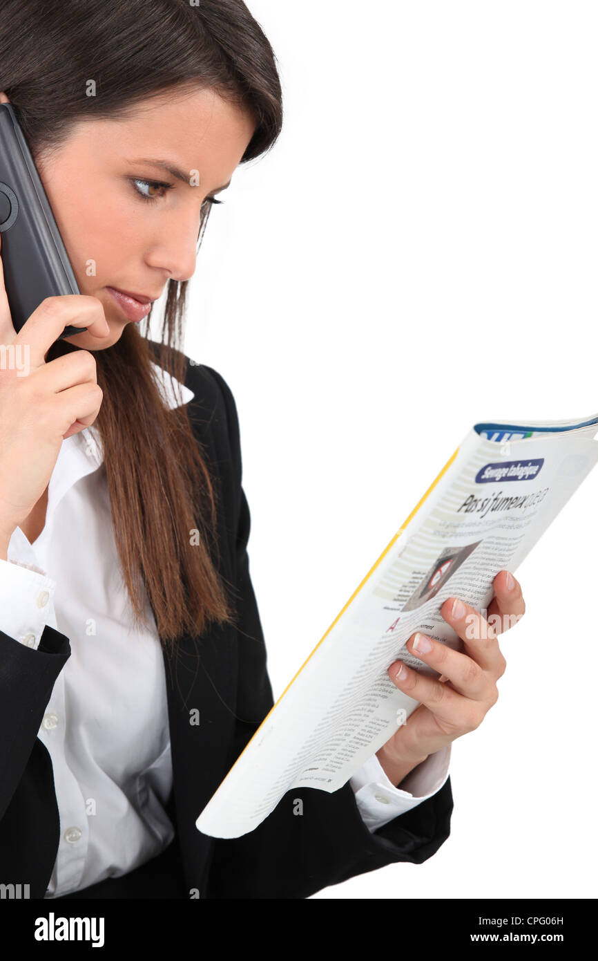 Woman calling an advert in a magazine Stock Photo - Alamy