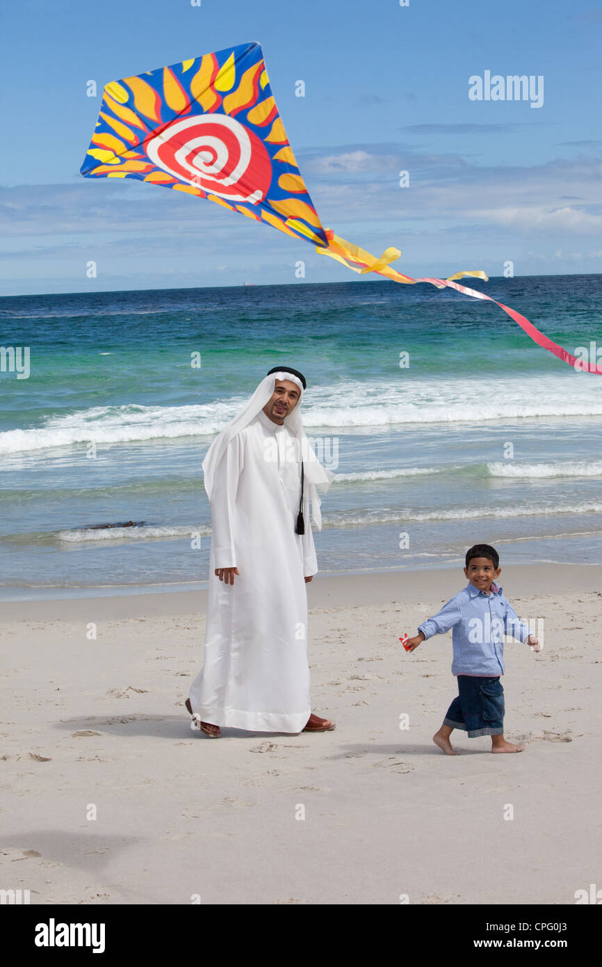 Arab father and son with kite walking at the beach Stock Photo - Alamy