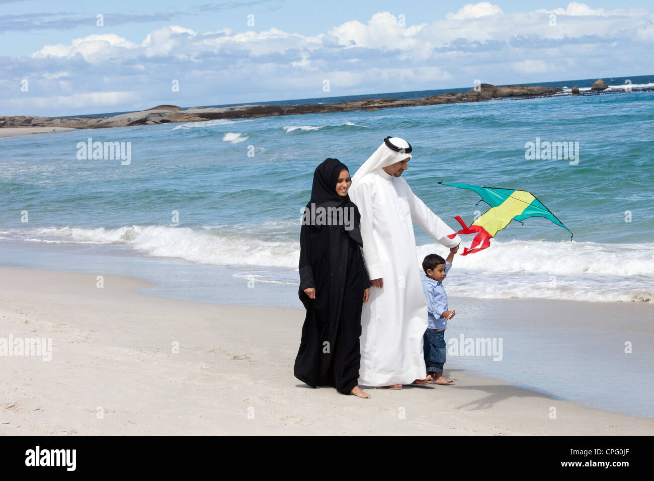 Arab family at the beach, son playing with kite Stock Photo - Alamy